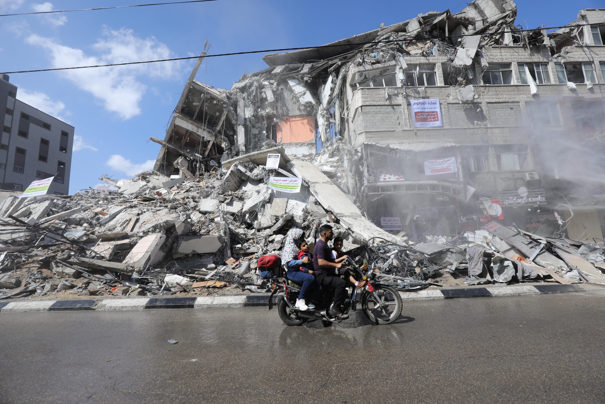 Palestinian volunteers sweep the rubble of buildings destroyed by ...