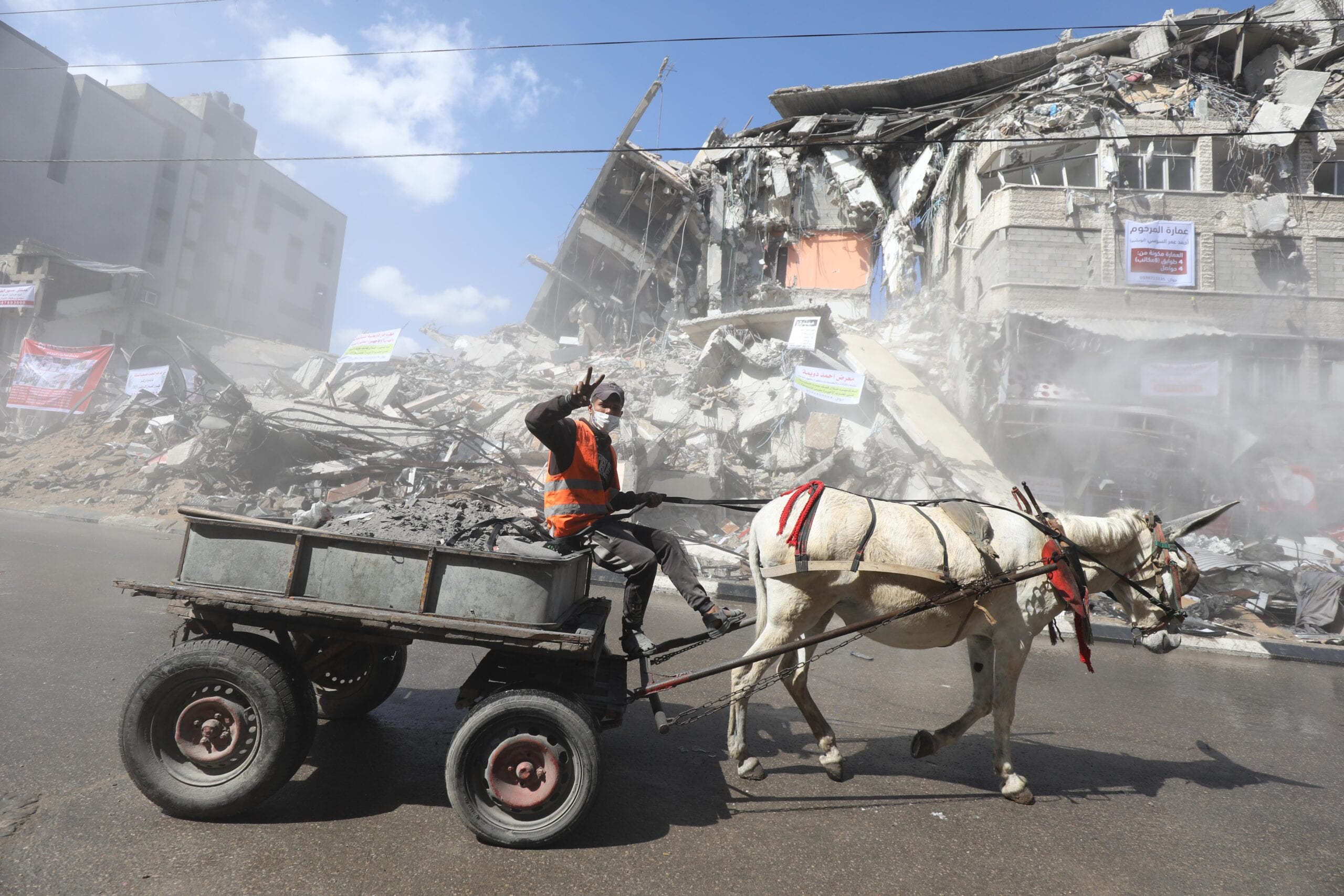 Palestinian volunteers sweep the rubble of buildings destroyed by ...